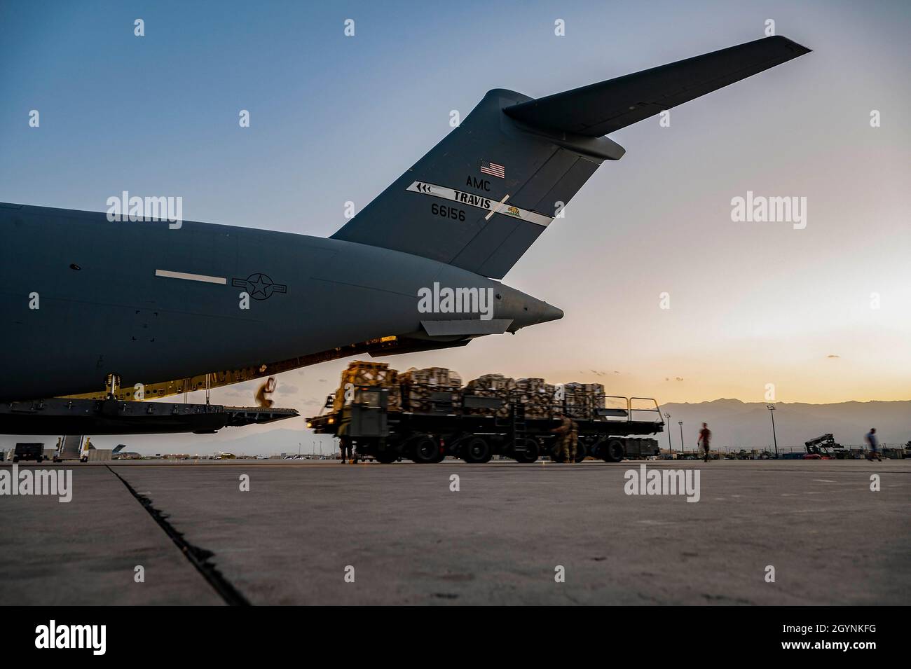 U.S. Air Force Airmen and civilian contractors prepare to load cargo ...