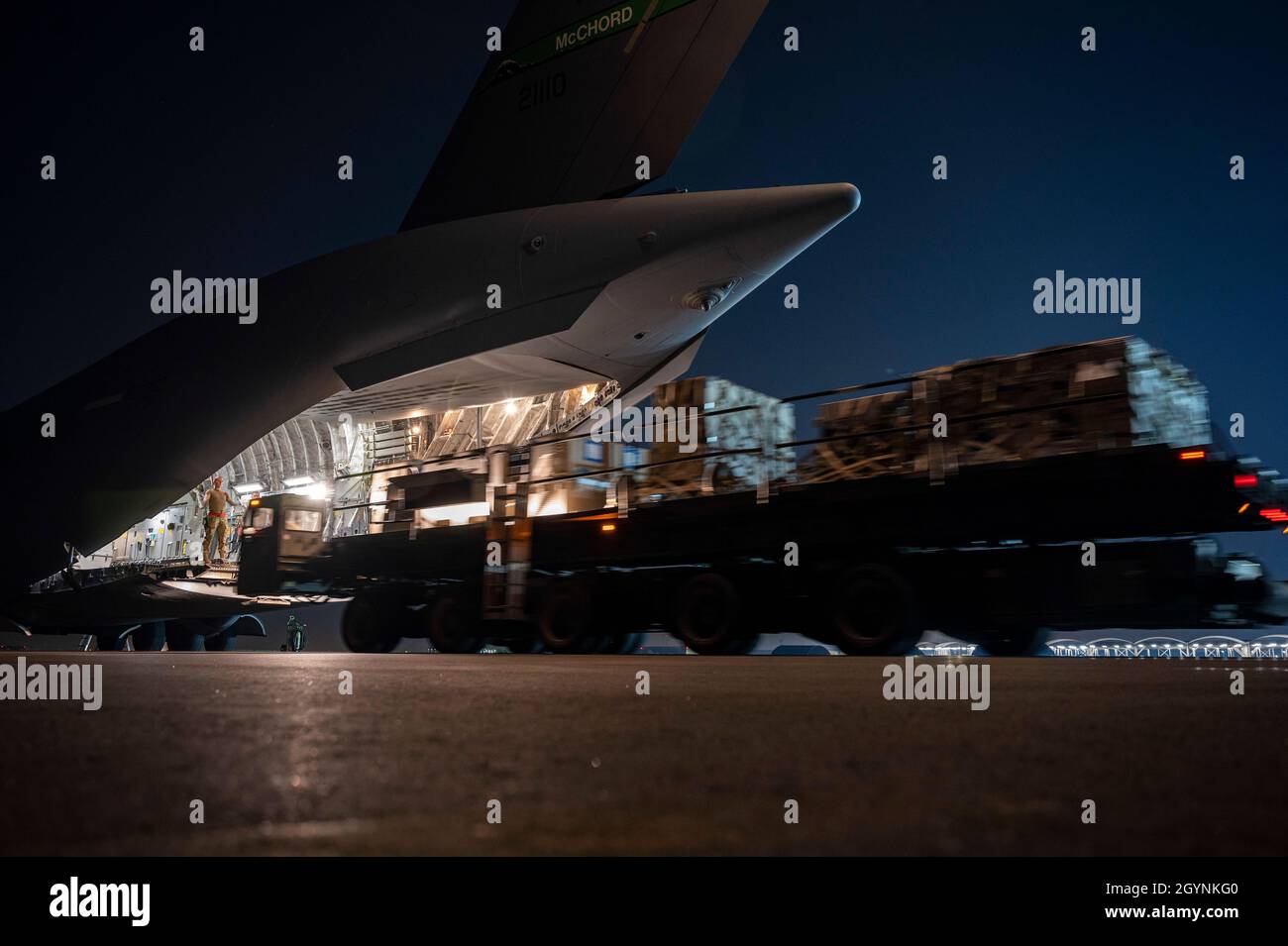 A U.S. Air Force container loader drives away after unloading cargo ...