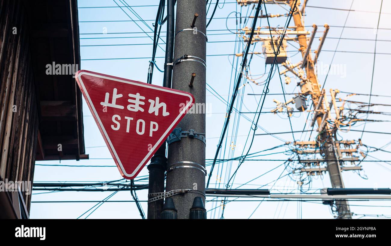 Red triangular stop warning traffic road sign with white letters kanji ...