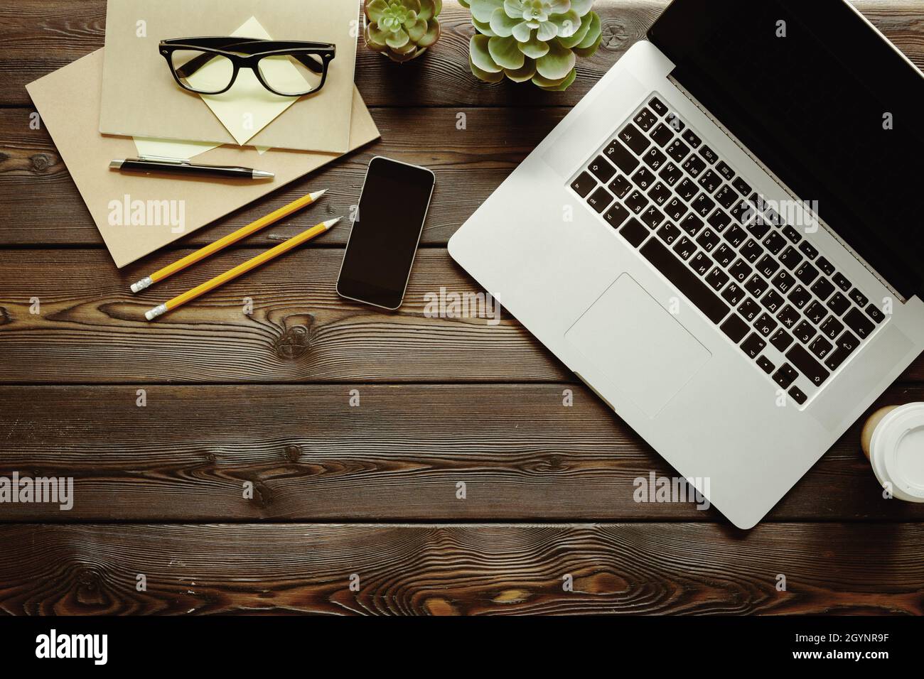 Dark wooden table with laptop, notepad top view Stock Photo - Alamy