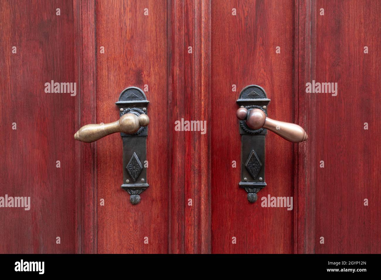 two Handles on an aged red wooden door. Concept historical luxury ...