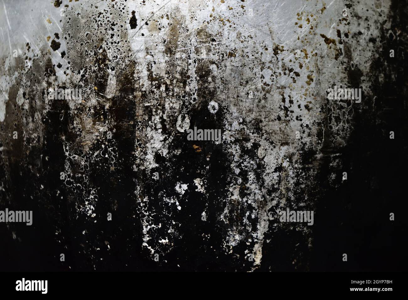 Brown and black color stain on the silver surface that has white ...