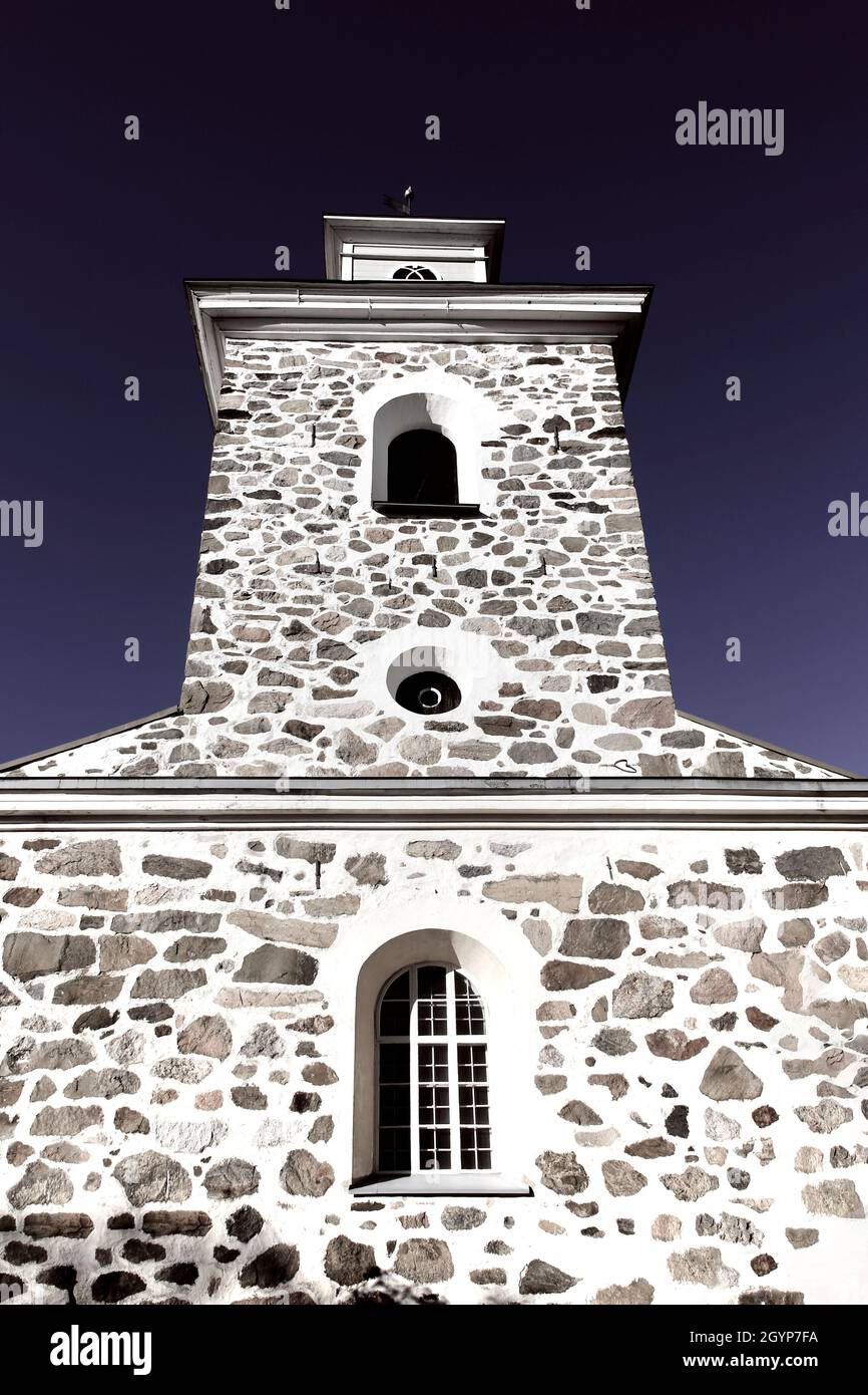 Belltower of greystone seen in dramatic light, front view, Nummi Church ...