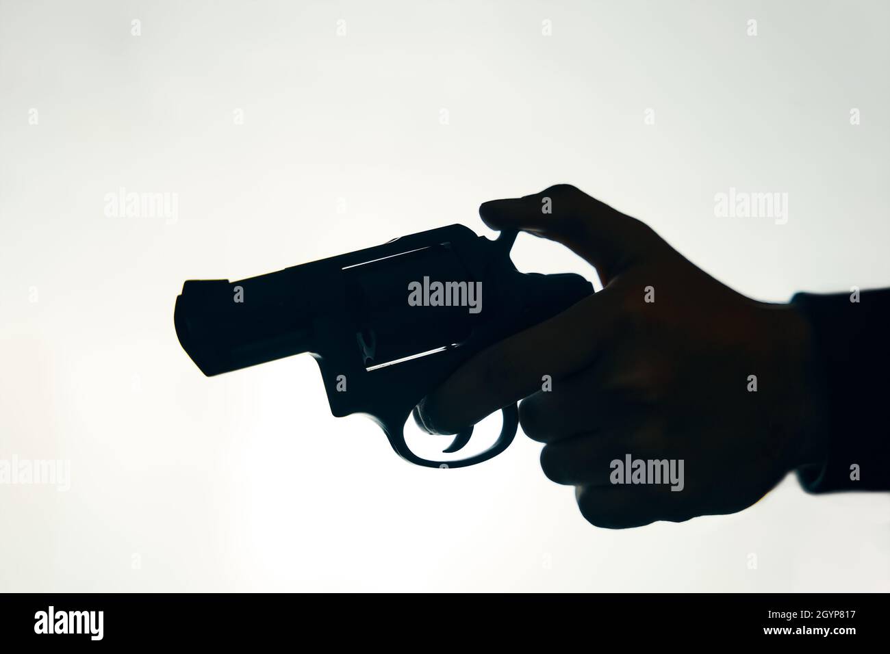 Silhouette of hand with gun on white background. Man pulls the trigger ...