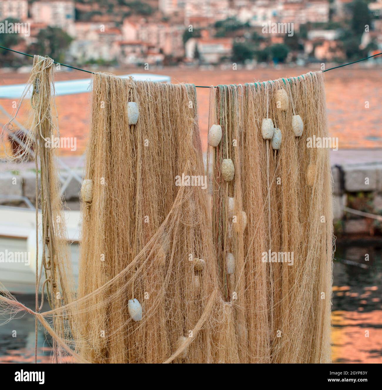 Fishing nets laid out to dry in the sun during sunset on a blurry ...