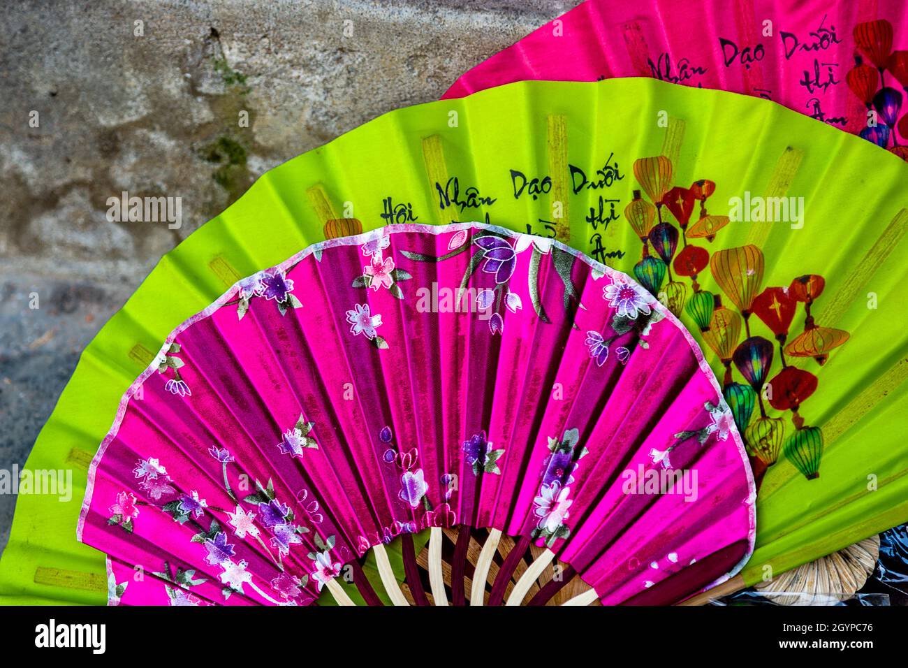 Three hand fans in different colors sitting next to each other in ...