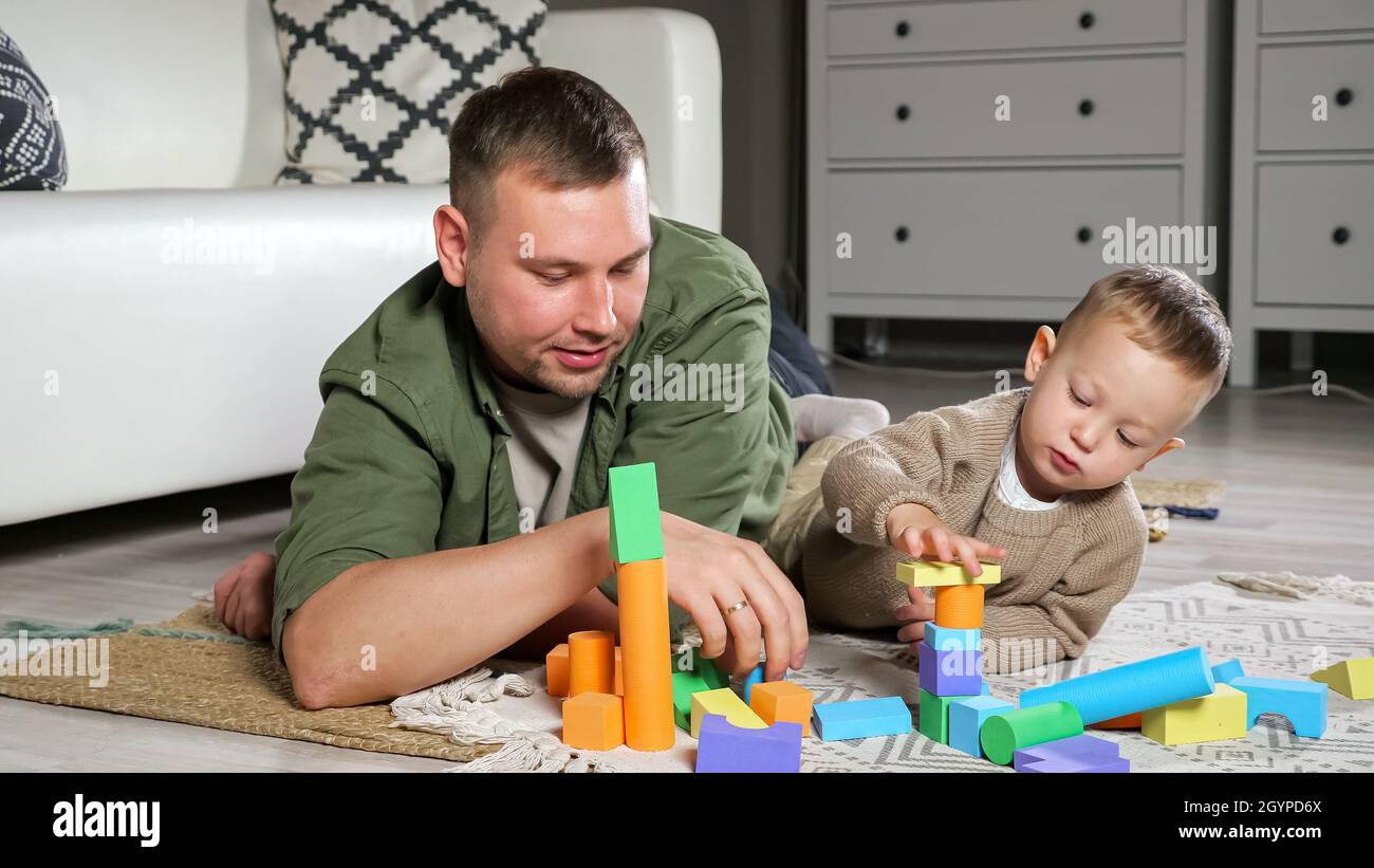 Father and son build tower using colorful wooden blocks Stock Photo - Alamy