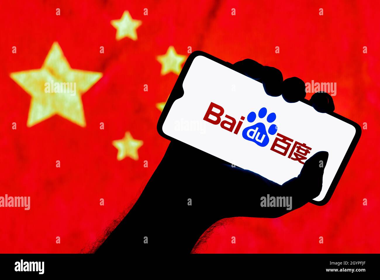 A smartphone with the Baidu logo in a clenched hand on the background ...