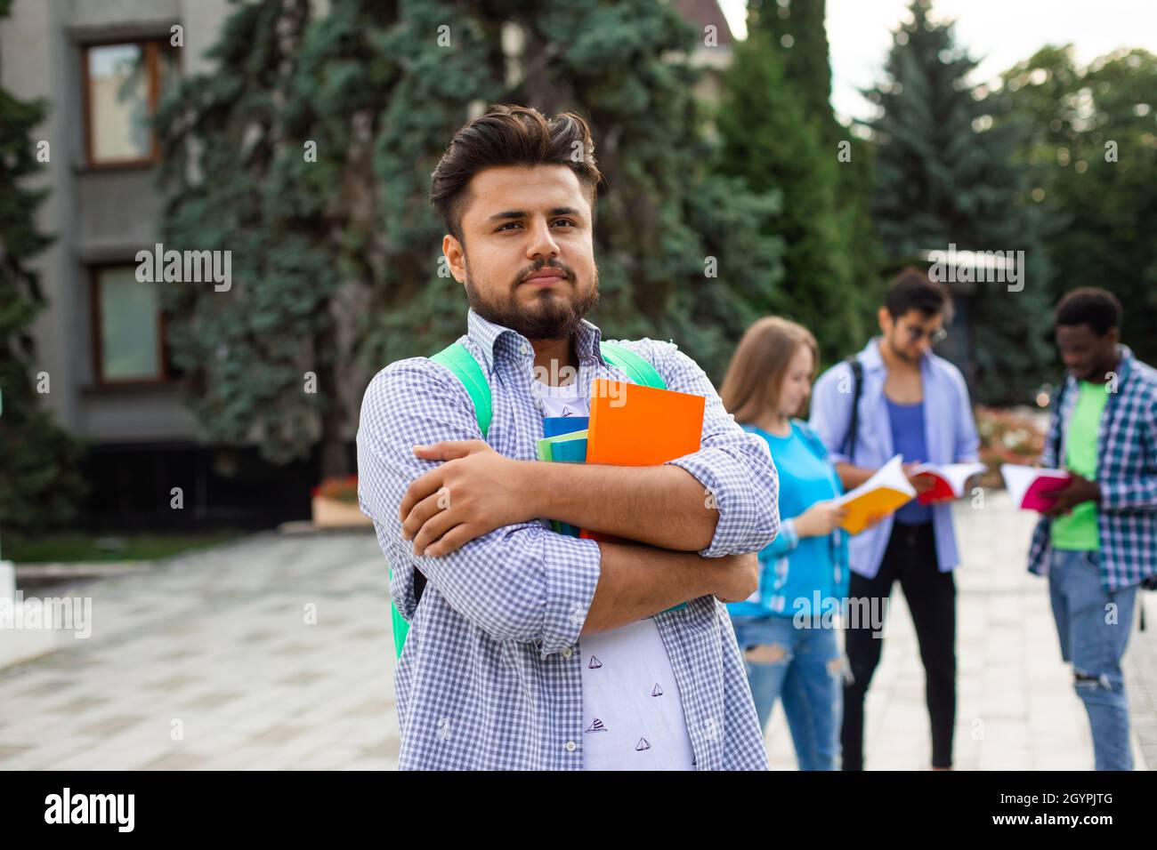 The student is hugging a stack of books outdoors Stock Photo - Alamy