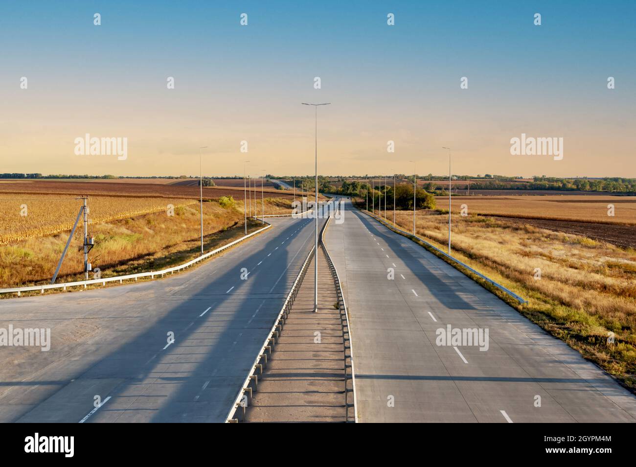 Concrete road with two-way traffic, dividing stripes, lighting, goes ...