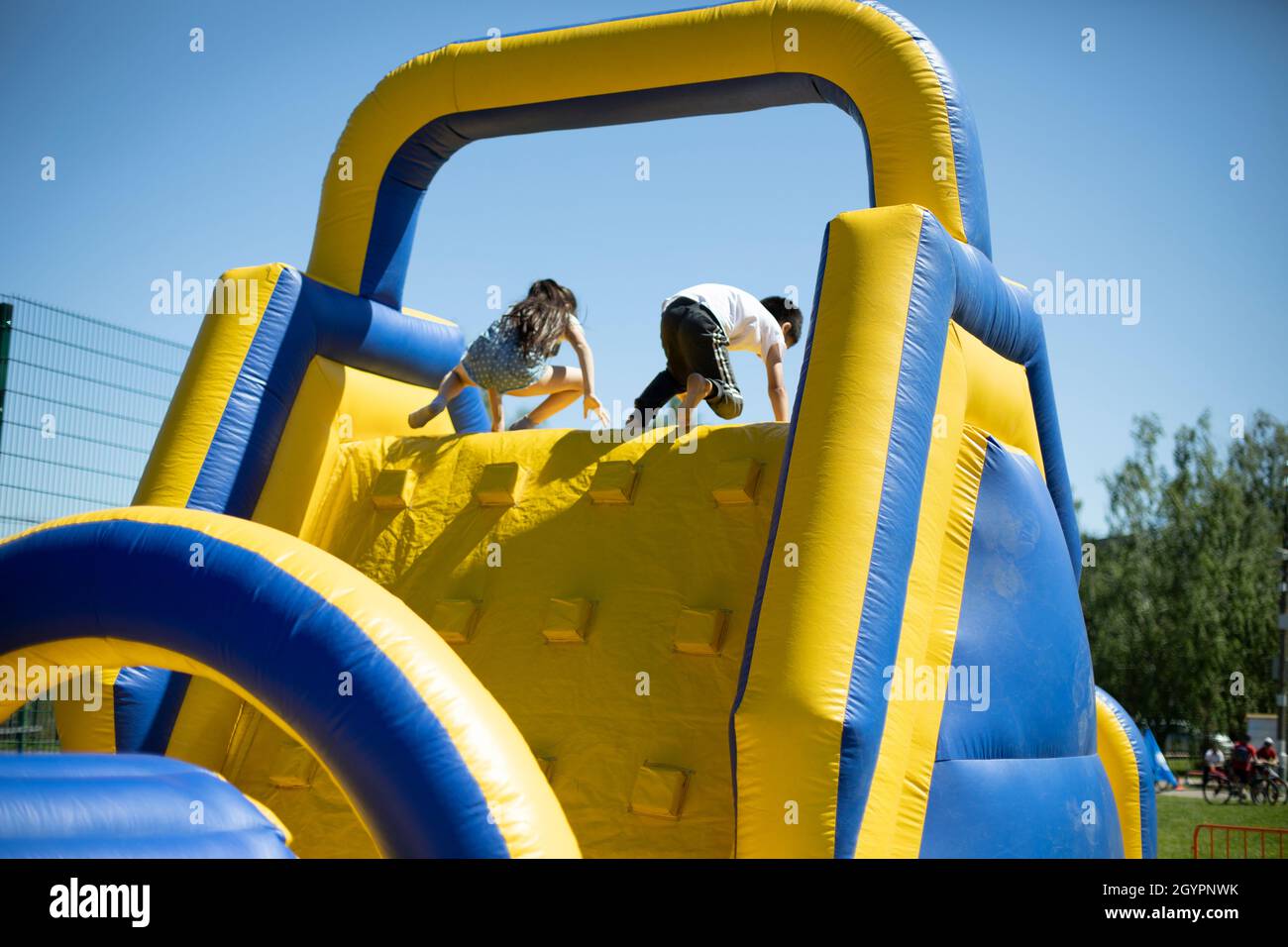 Children climb an inflatable slide. Inflatable obstacle course for fun ...