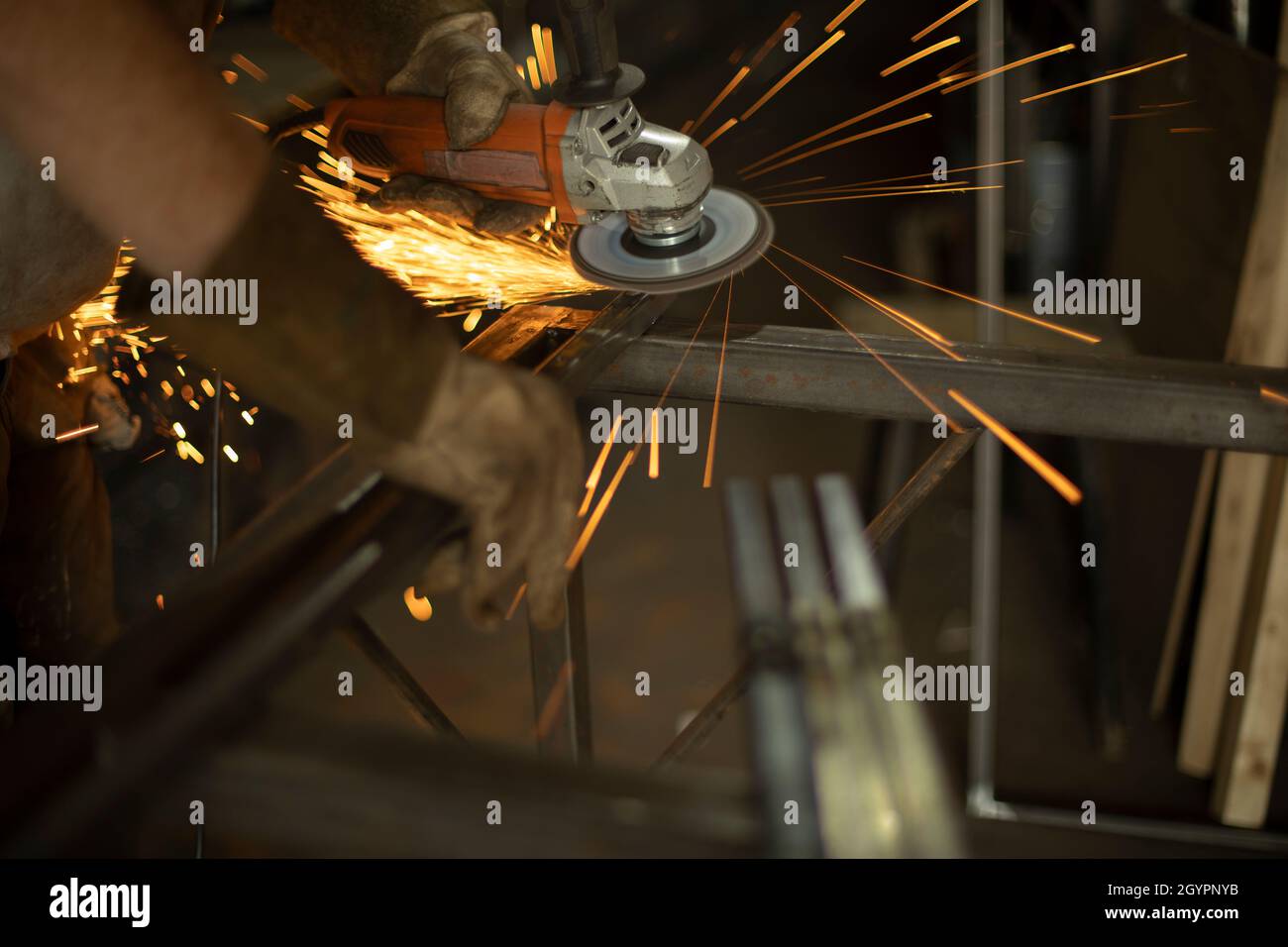 Work grinding machine. Sparks from the force of friction. A man in a ...