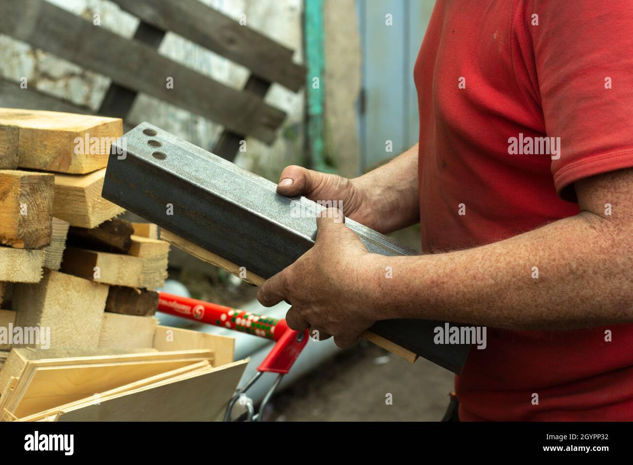 Worker with metal. The guy holds a steel part. Hard work in a ...