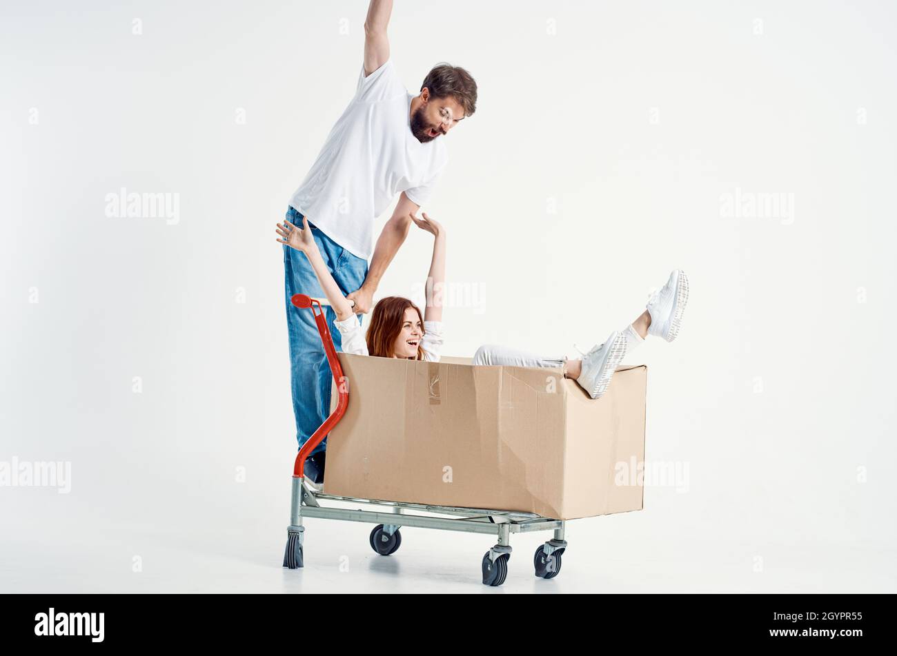 a young couple ride a cart entertainment light background Stock Photo ...