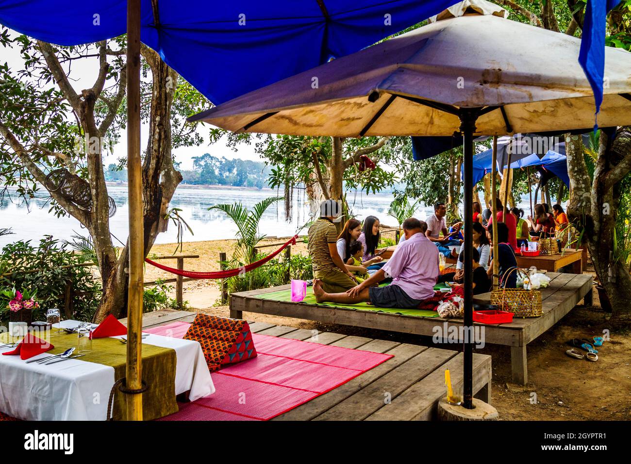 A tour group eating Khmer food on a raised platform at a Khmer ...