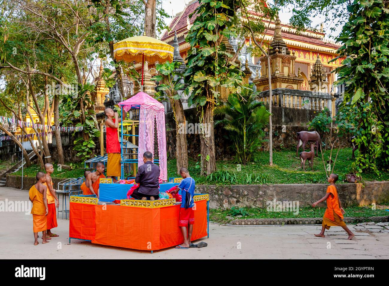 A group of monks and monks in training pray at a platform on the lake ...