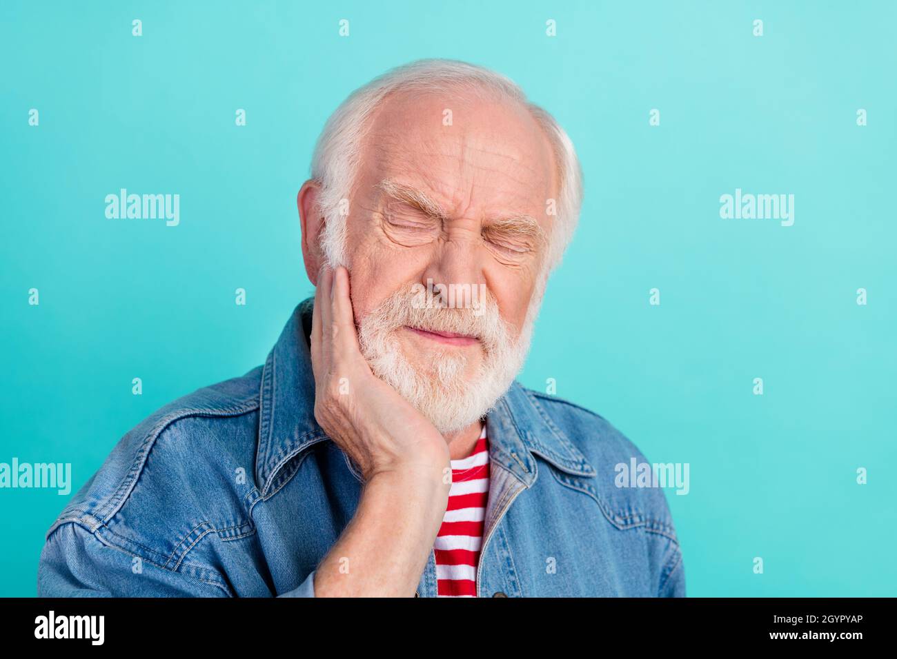 Portrait of attractive depressed grey-haired man touching cheek teeth ...