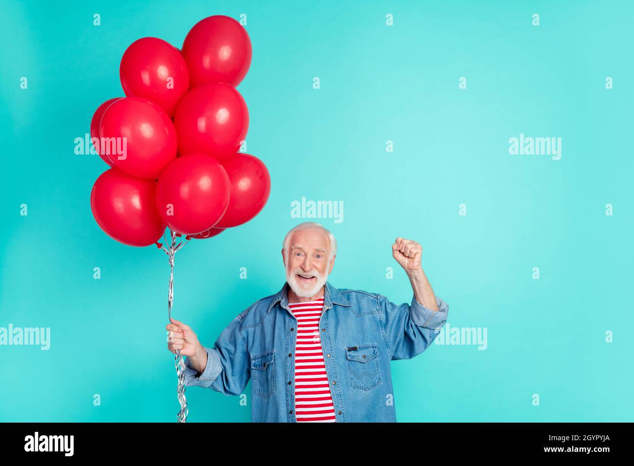 Portrait of attractive cheerful grey-haired man holding helium balls ...