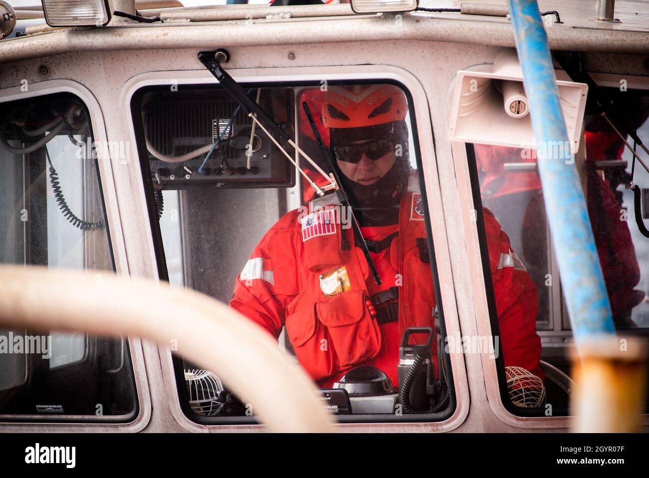U.S. Coast Guard Chief Petty Officer Joshua DeHaan takes the helm of a ...