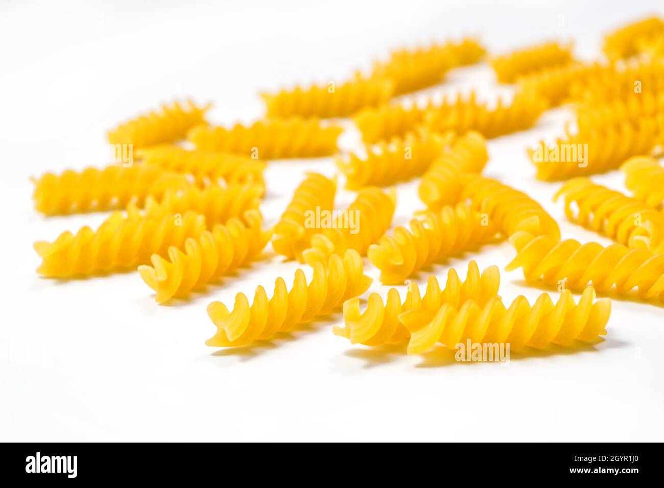 Raw Fusilli pasta, isolated on white background, selective focus ...