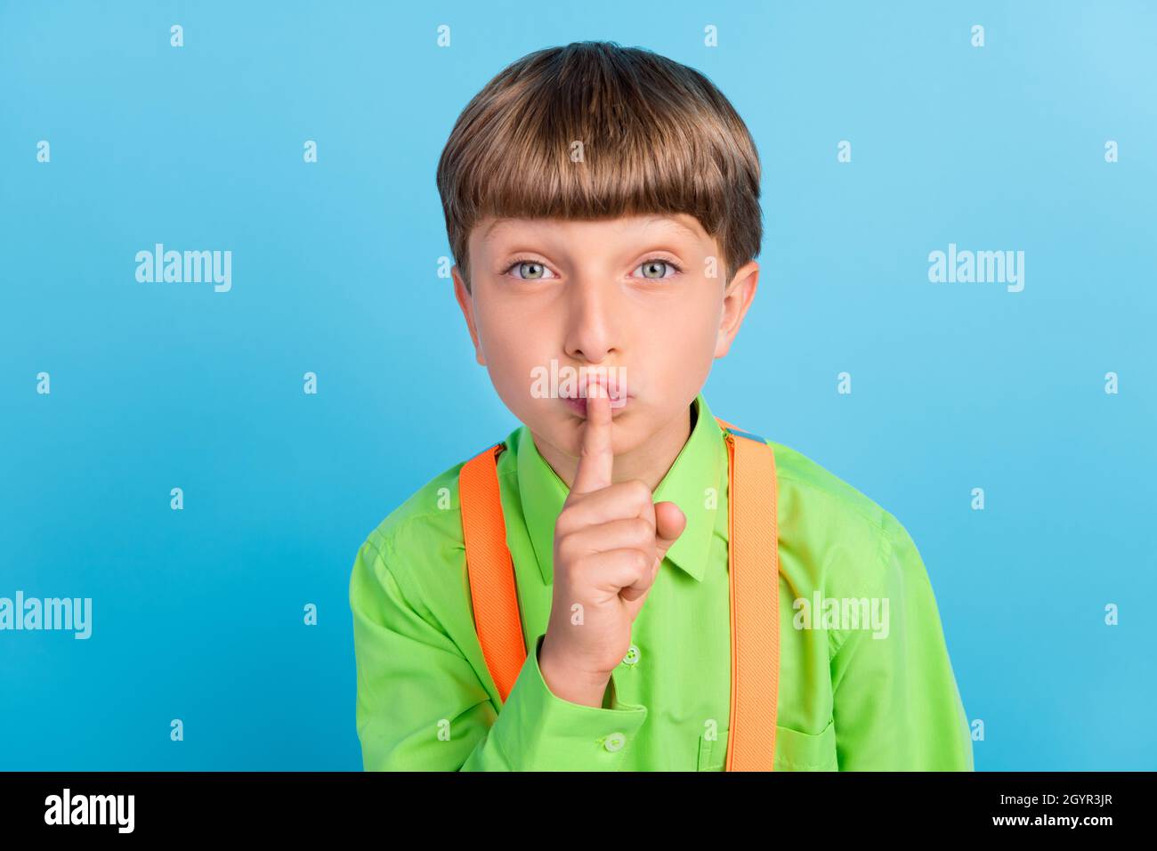 Photo portrait little boy keeping secret finger newar lips wearing ...