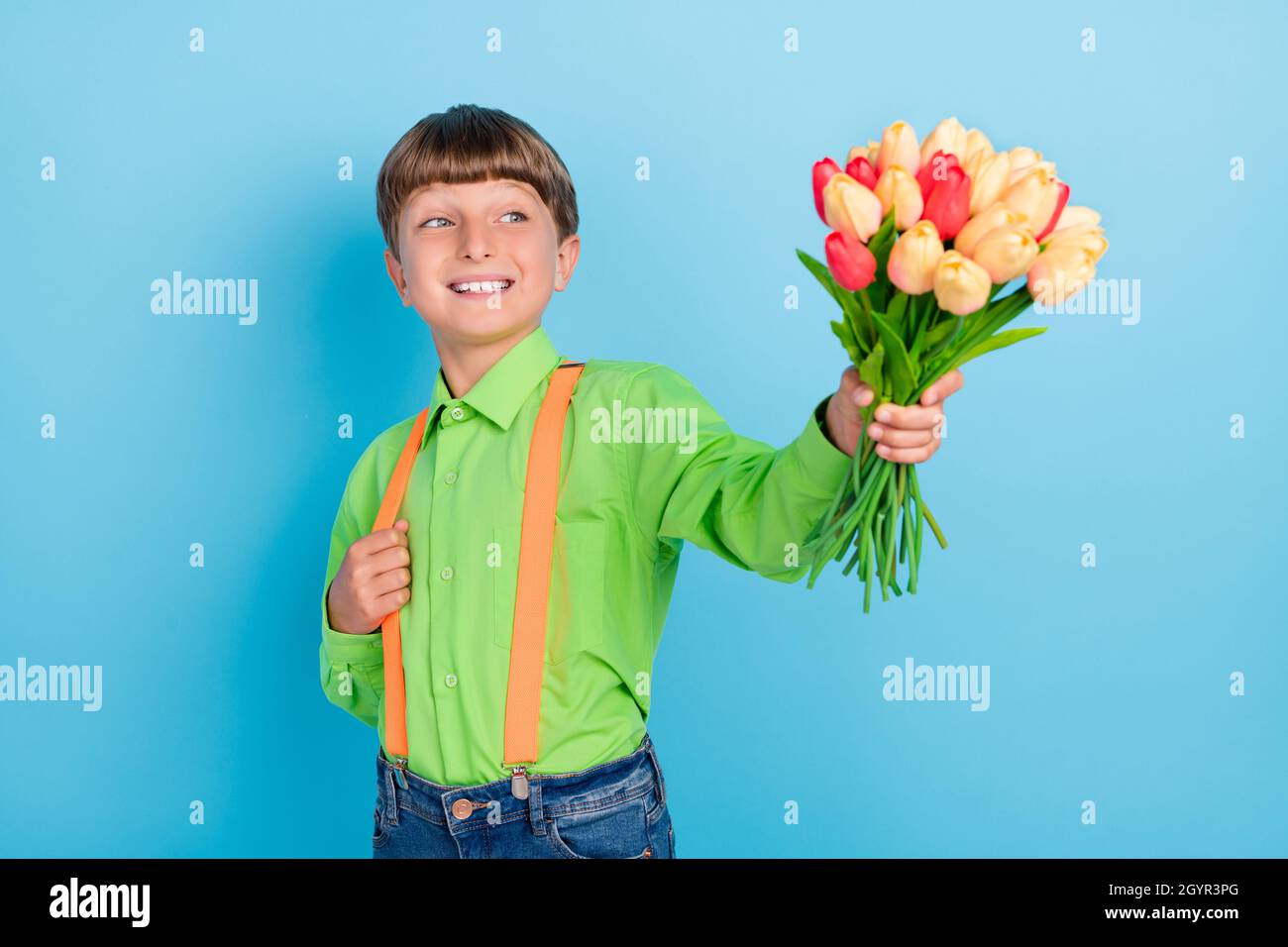 Portrait of attractive cheery boy nerd giving fresh flowers greetings ...