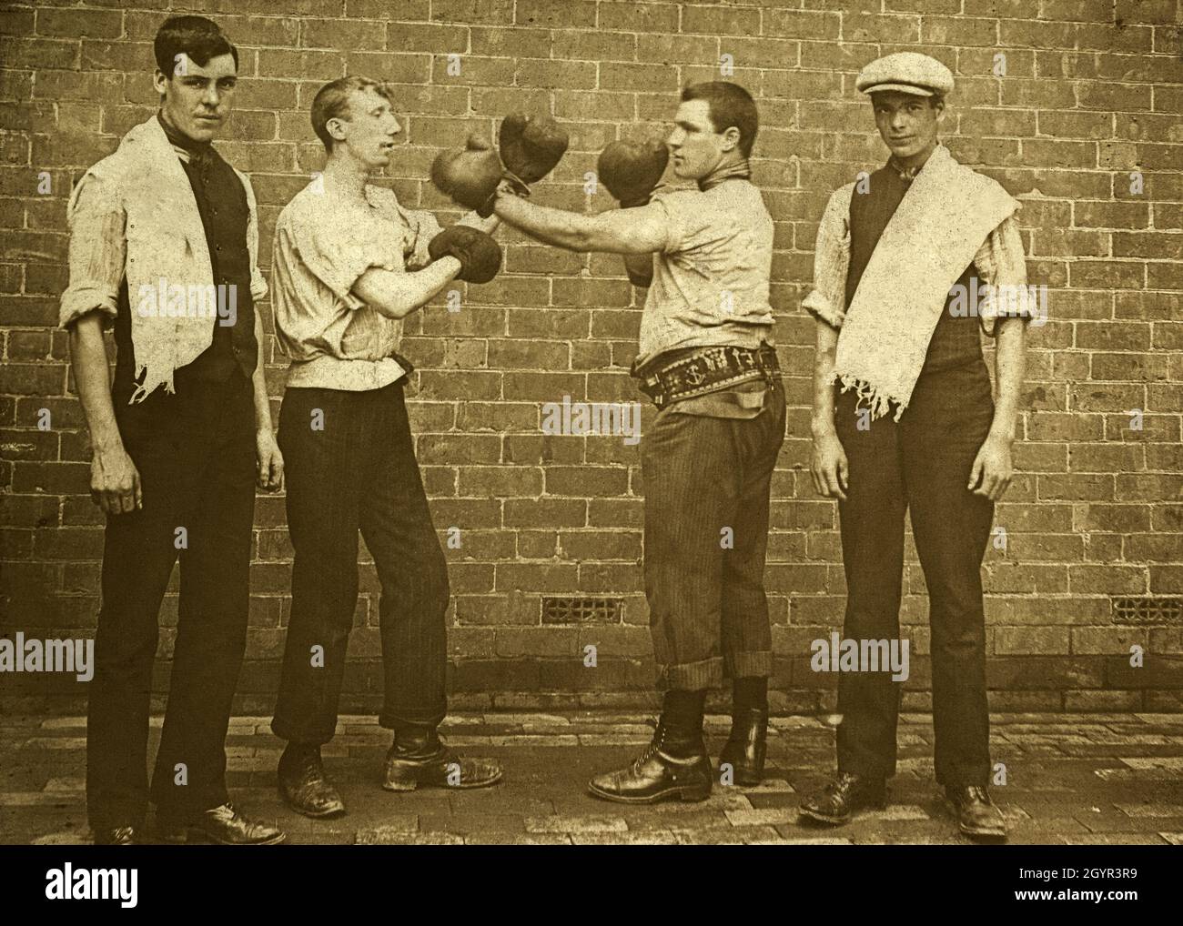 Early 1900s boxers in sparring pose, flanked by their seconds with ...