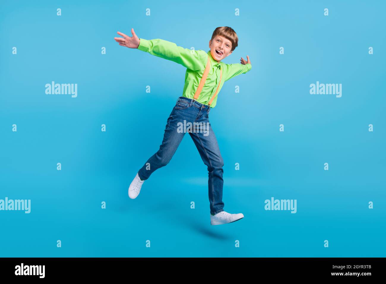 Full size photo of positive cheerful active small boy jump up enjoy ...