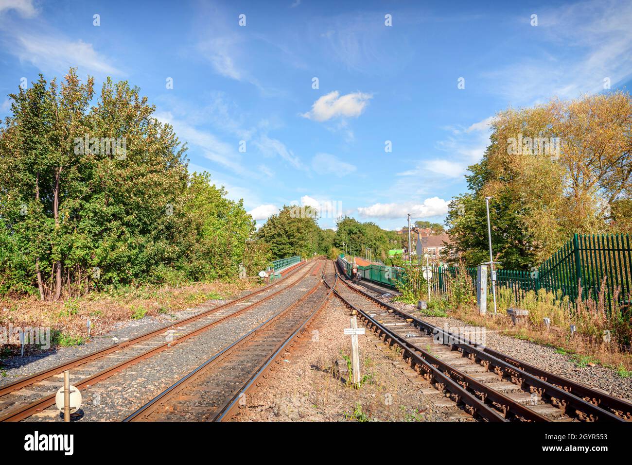 A railway bridge carrying rails over a river. There are trees on both ...