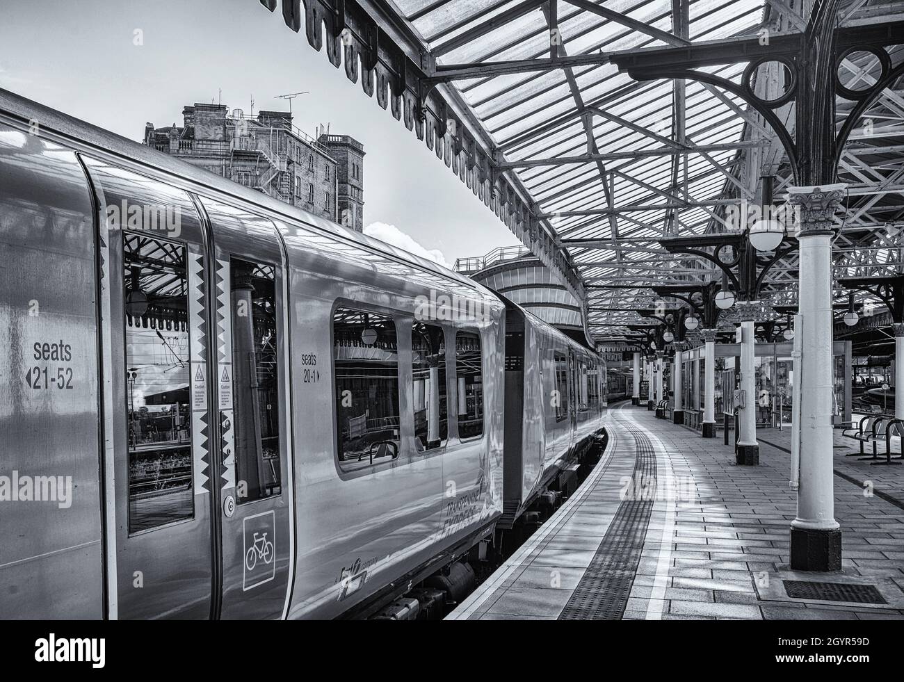 The carriages of a train at a station platform with an historic canopy ...