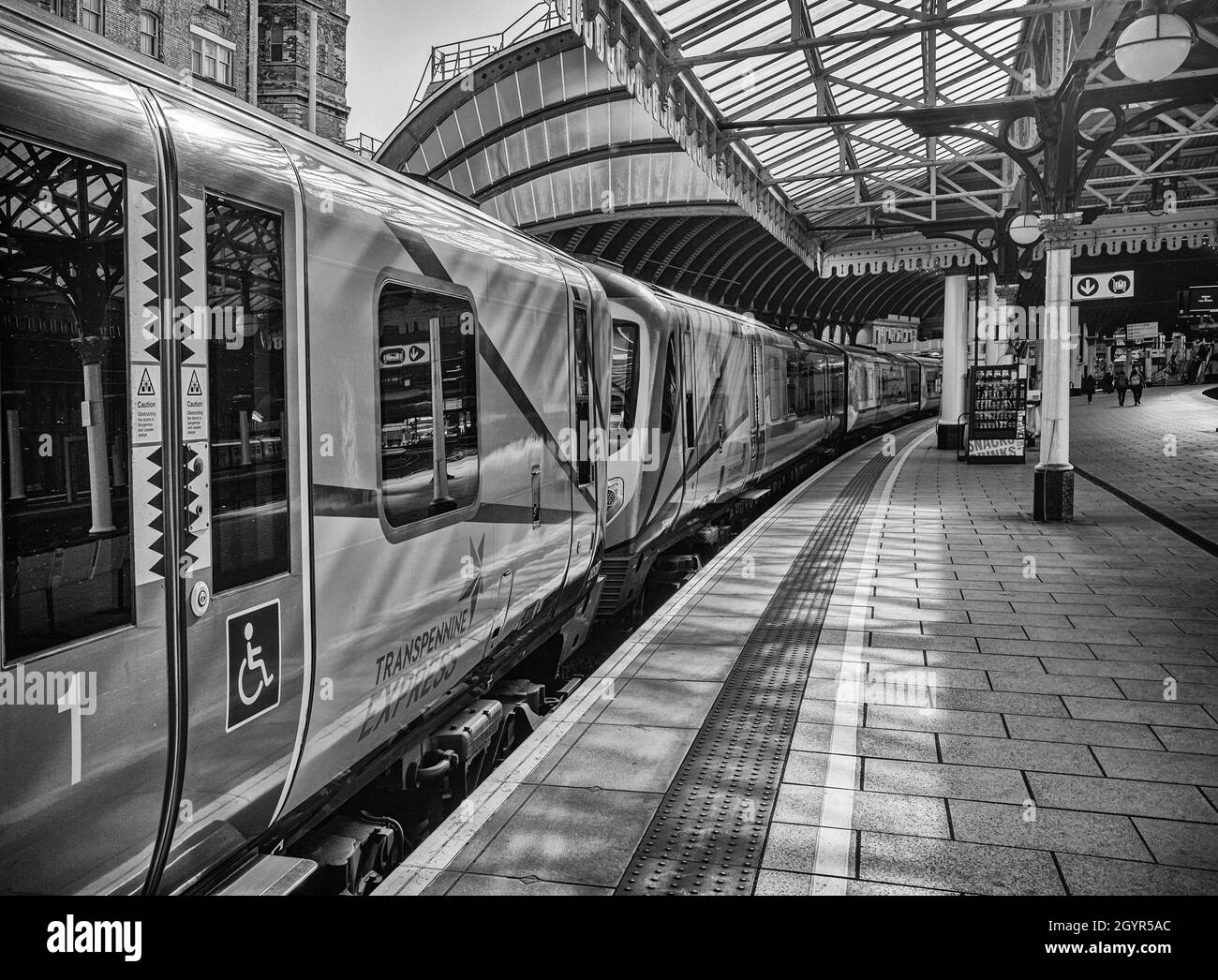 The carriages of a train at a station platform with an historic canopy ...