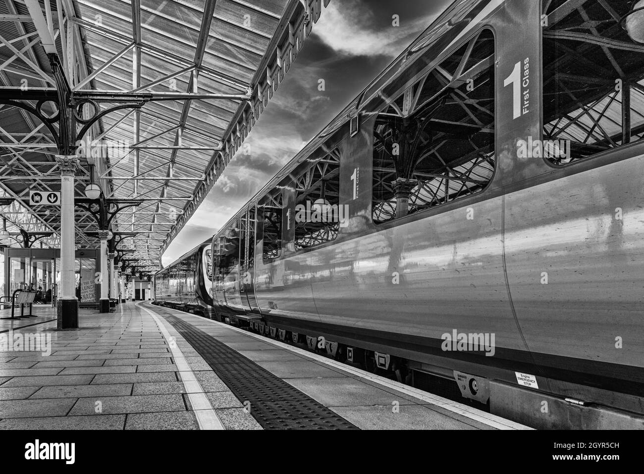 The carriages of a train at a station platform with an historic canopy ...