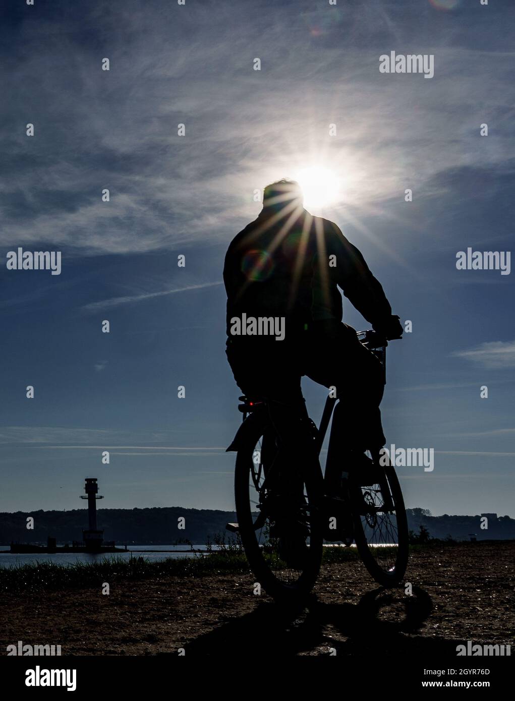 Kiel, Germany. 09th Oct, 2021. The sun shines in a cyclist's face as he ...