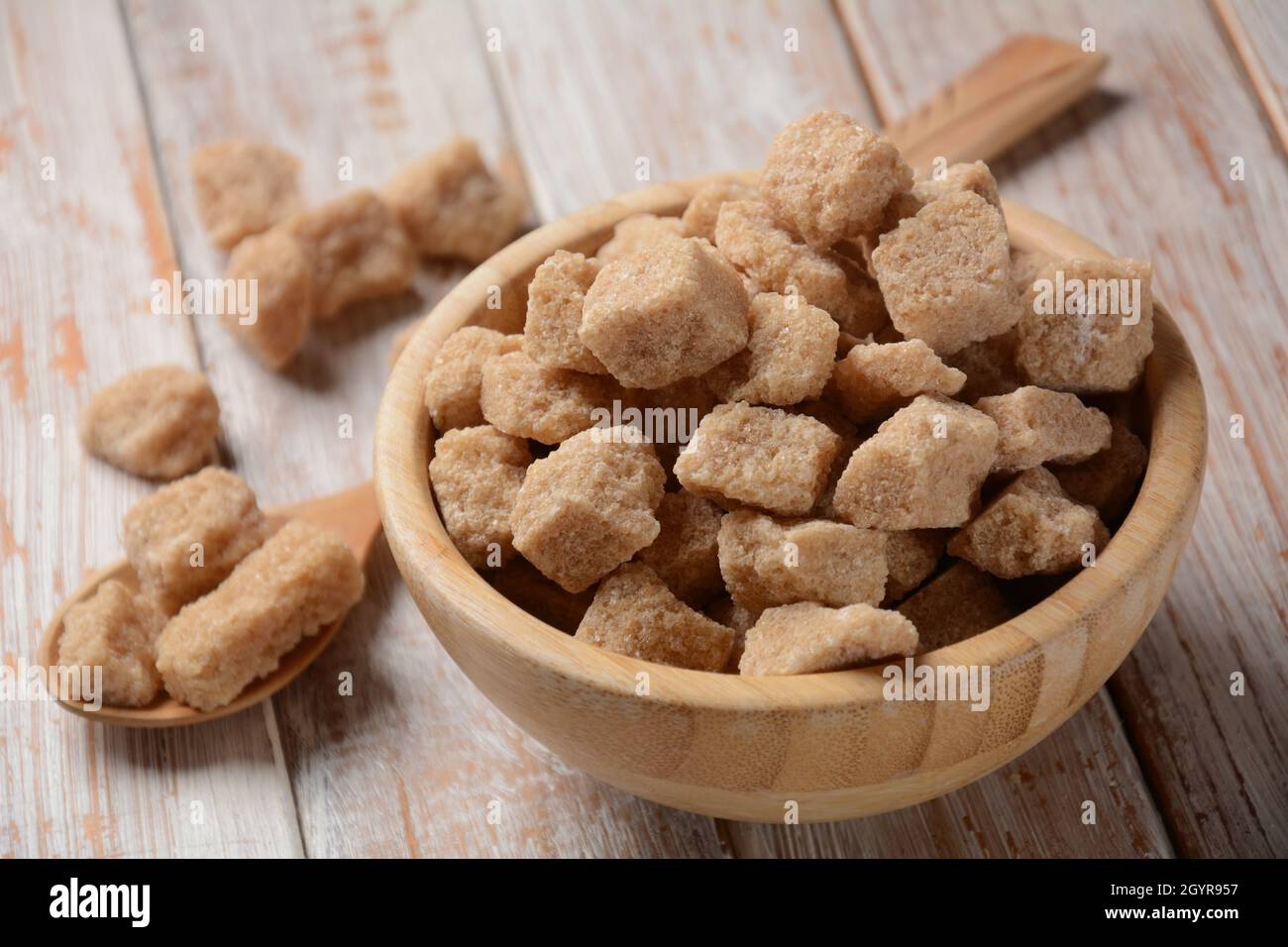 Demerara brown sugar cubes in wooden bowl. Also called sugar lumbs ...