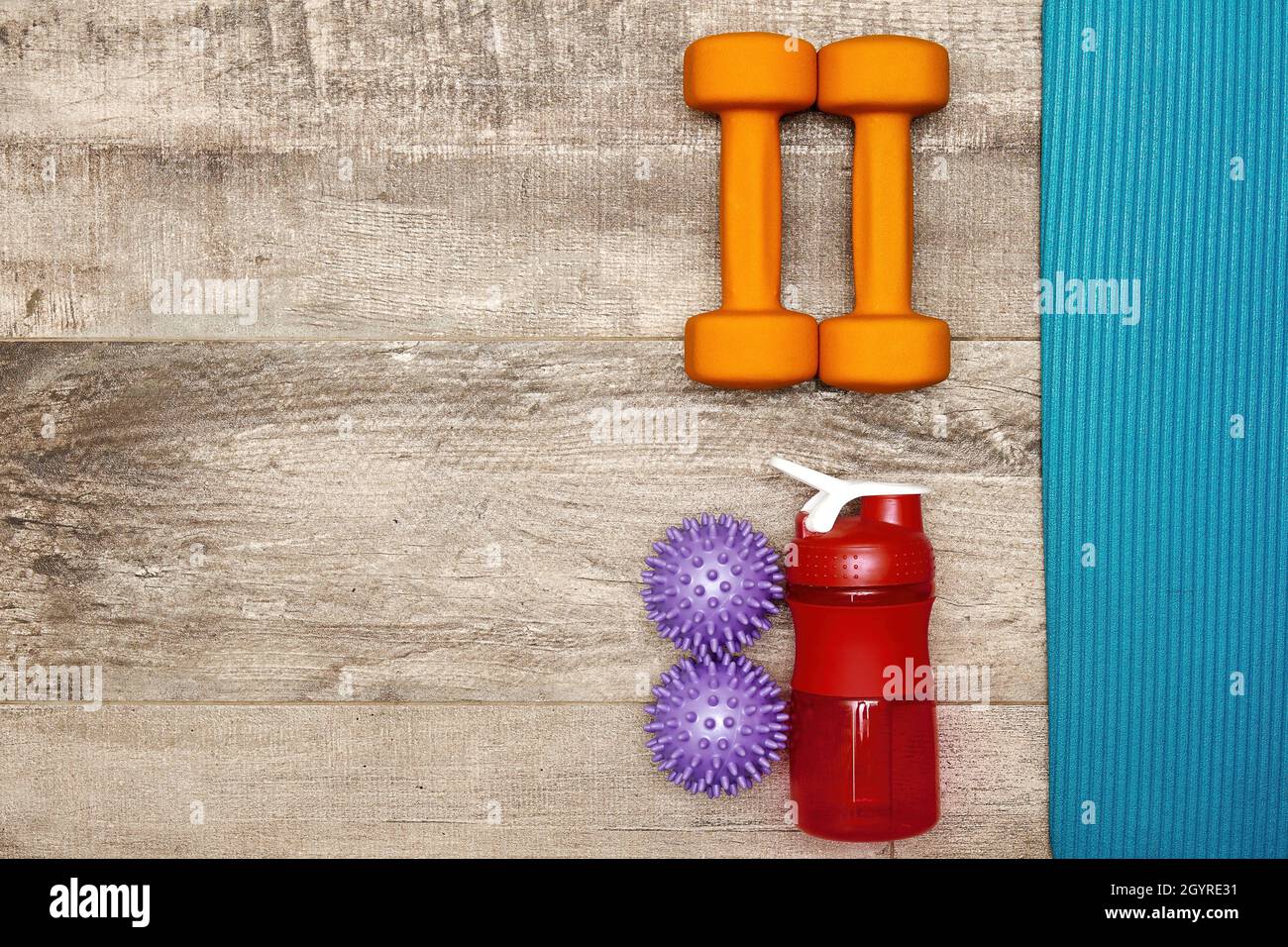 Flat Lay layout with fitness equipment on the wooden floor. Sports and ...