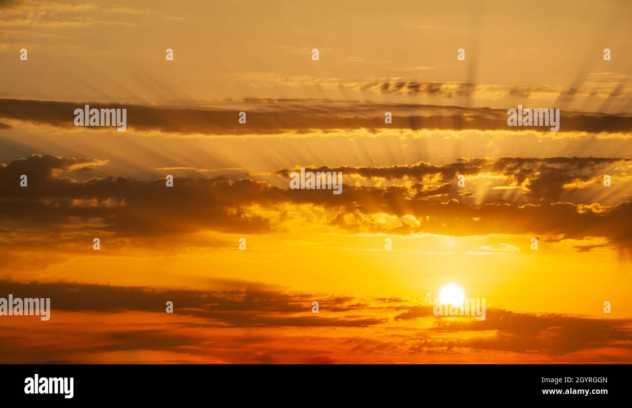 Sunbeams breaking through the dark clouds at sunset. Only sky, no land ...
