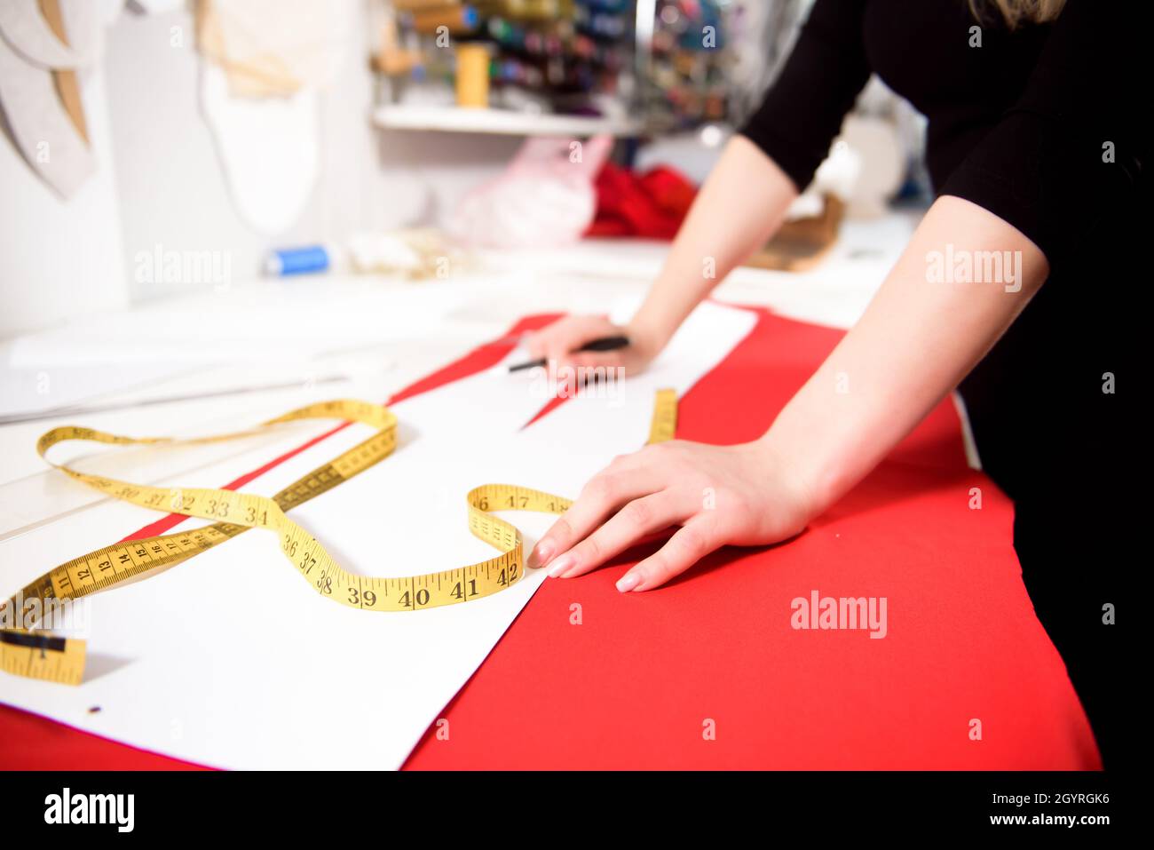 Young dressmaker woman sews clothes on sewing machine Stock Photo - Alamy