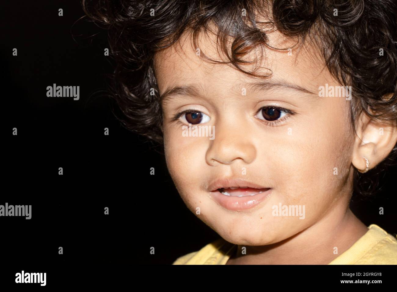 Close up face photo of a young indian child talking with black isolated ...