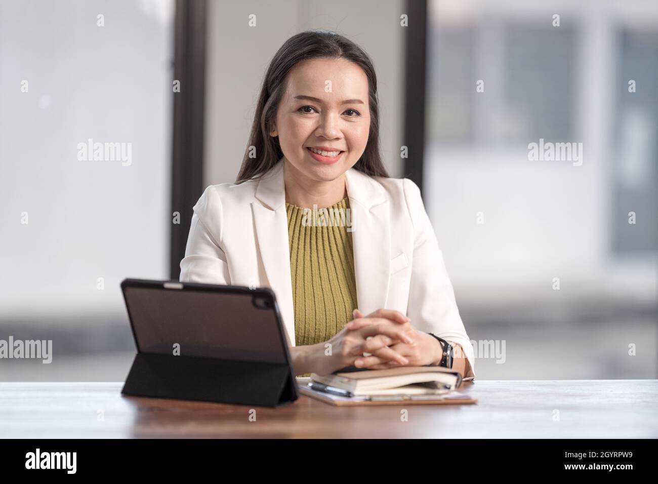Horizontal shot of a beautiful Asian tutor with tablet, copybook and pen Stock Photo - Alamy