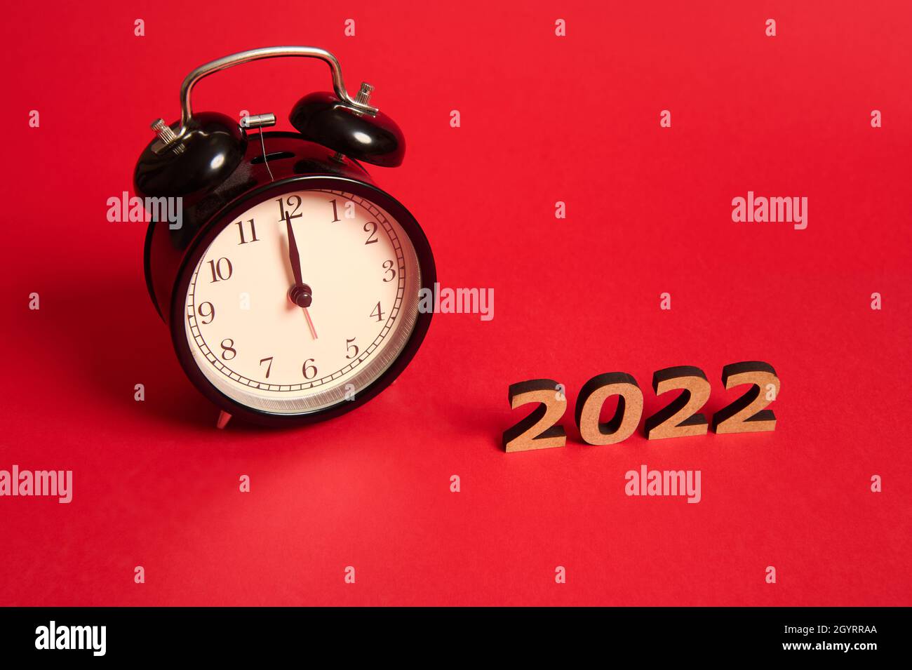 Black alarm clock with midnight on the clock face and wooden numbers ...