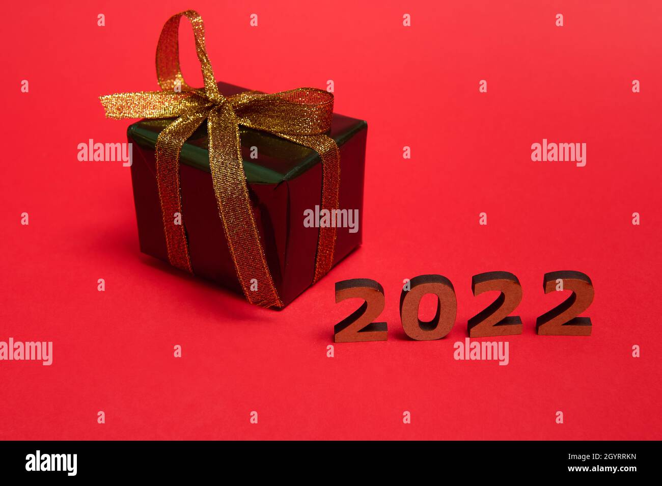 Small gift box wrapped in shiny glitter green wrapping paper and gold ...