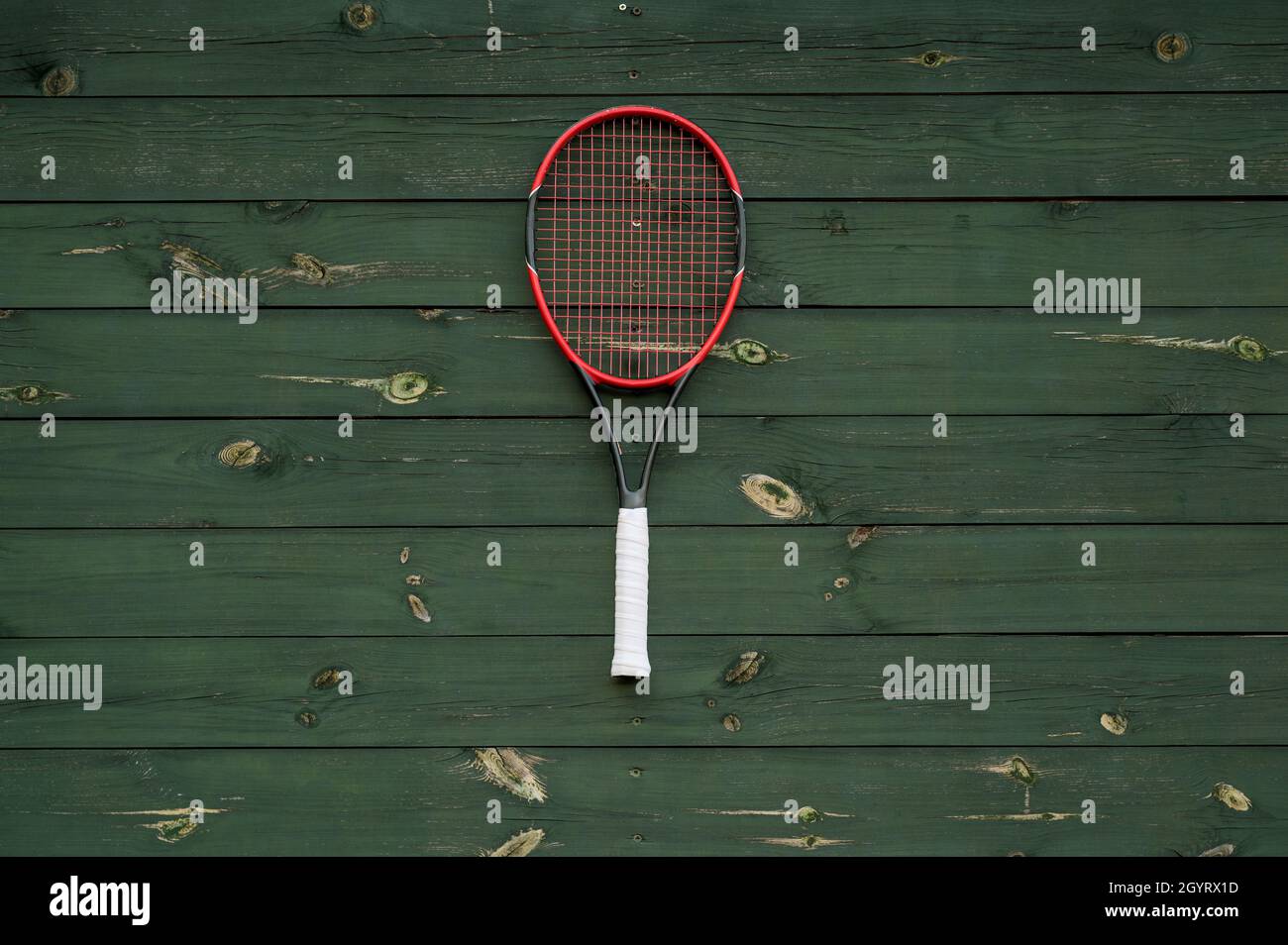 Tennis racket hanging on green wooden wall Stock Photo - Alamy