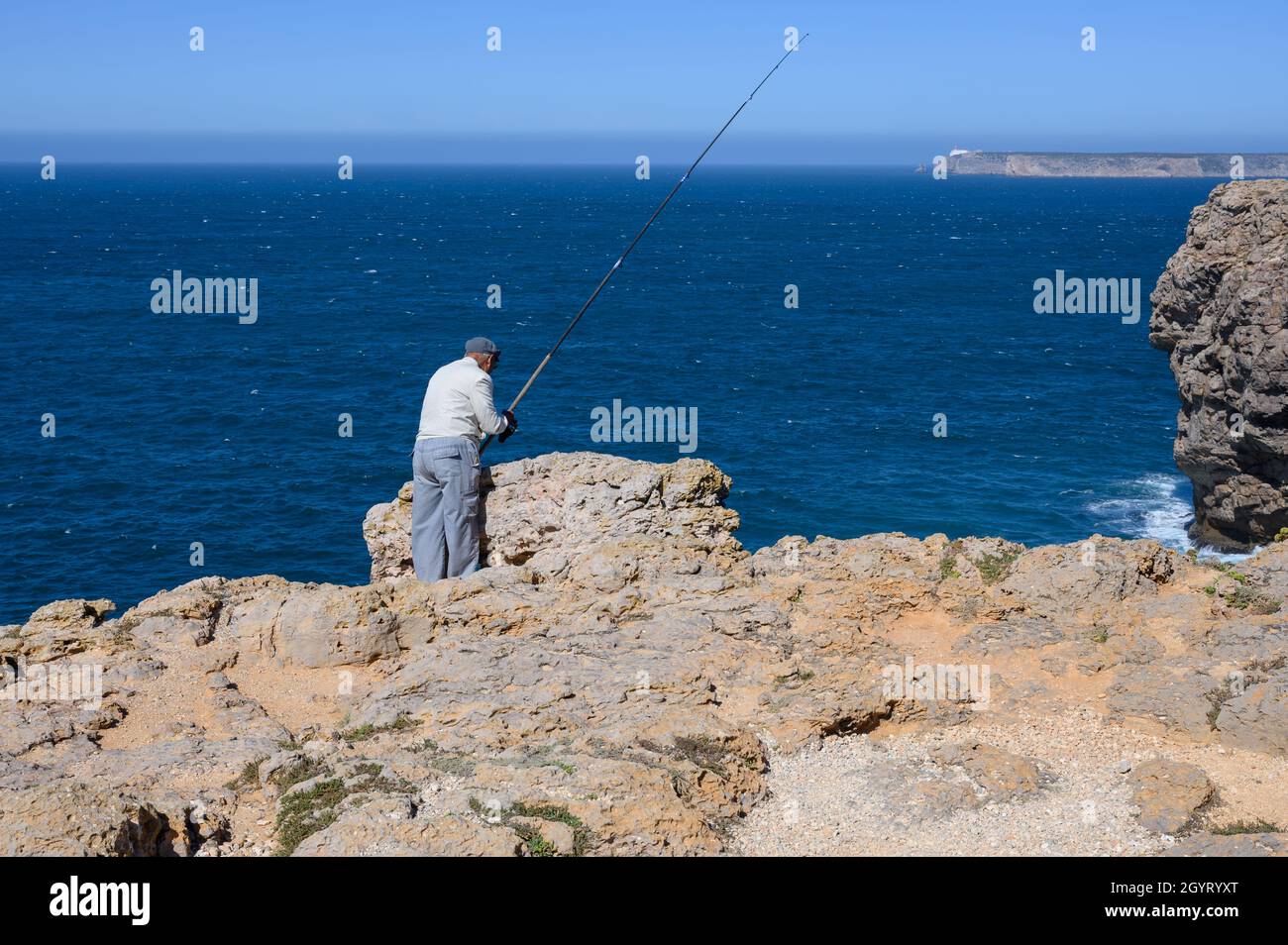 A lonesome old fisherman is catching his dinner with an huge fishing ...