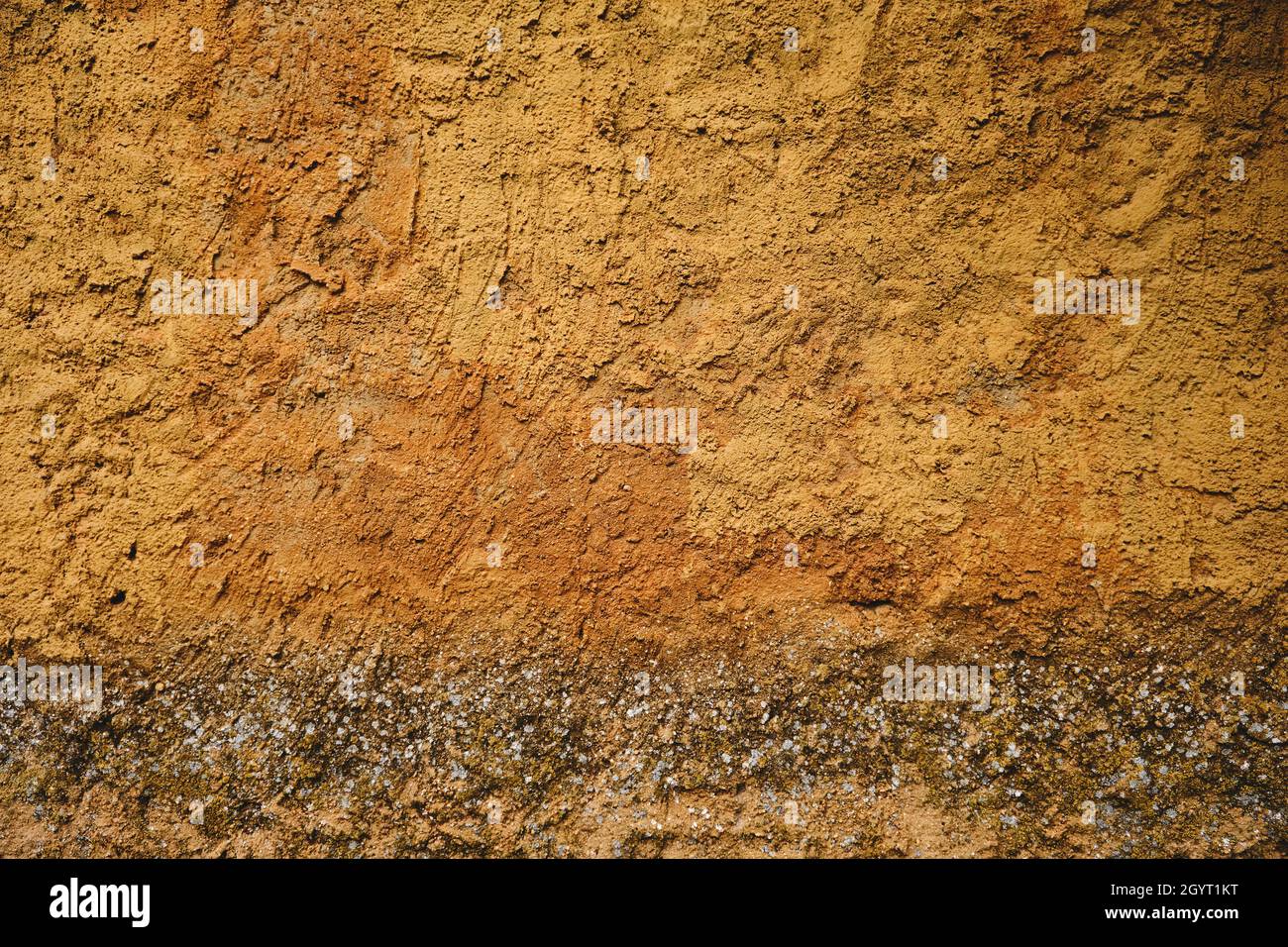 Ochre colored cement plaster coating wall with damp, grungy rustic ...