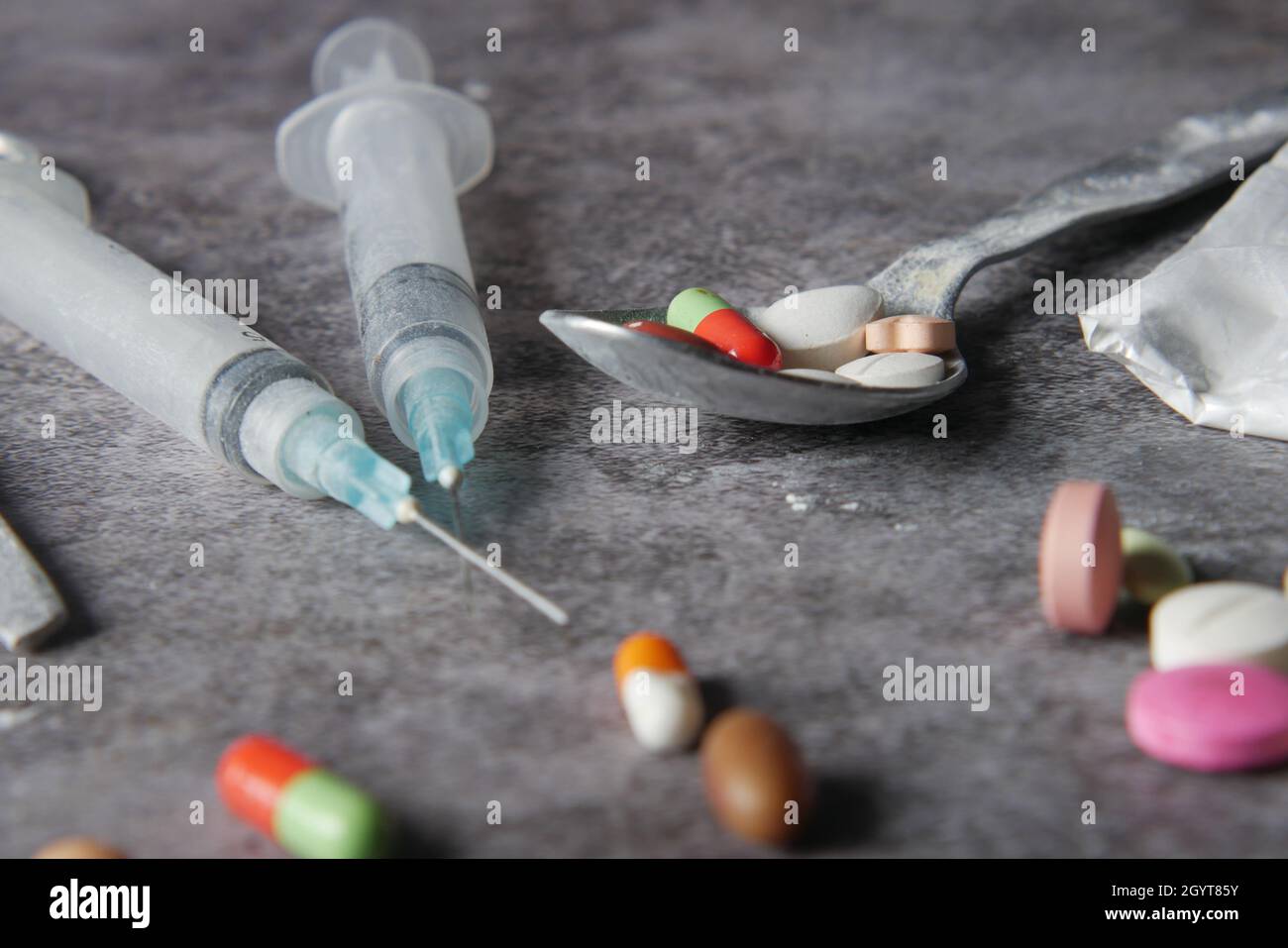 Drug Addiction Concept With Heroine Packet And Syringe On Black