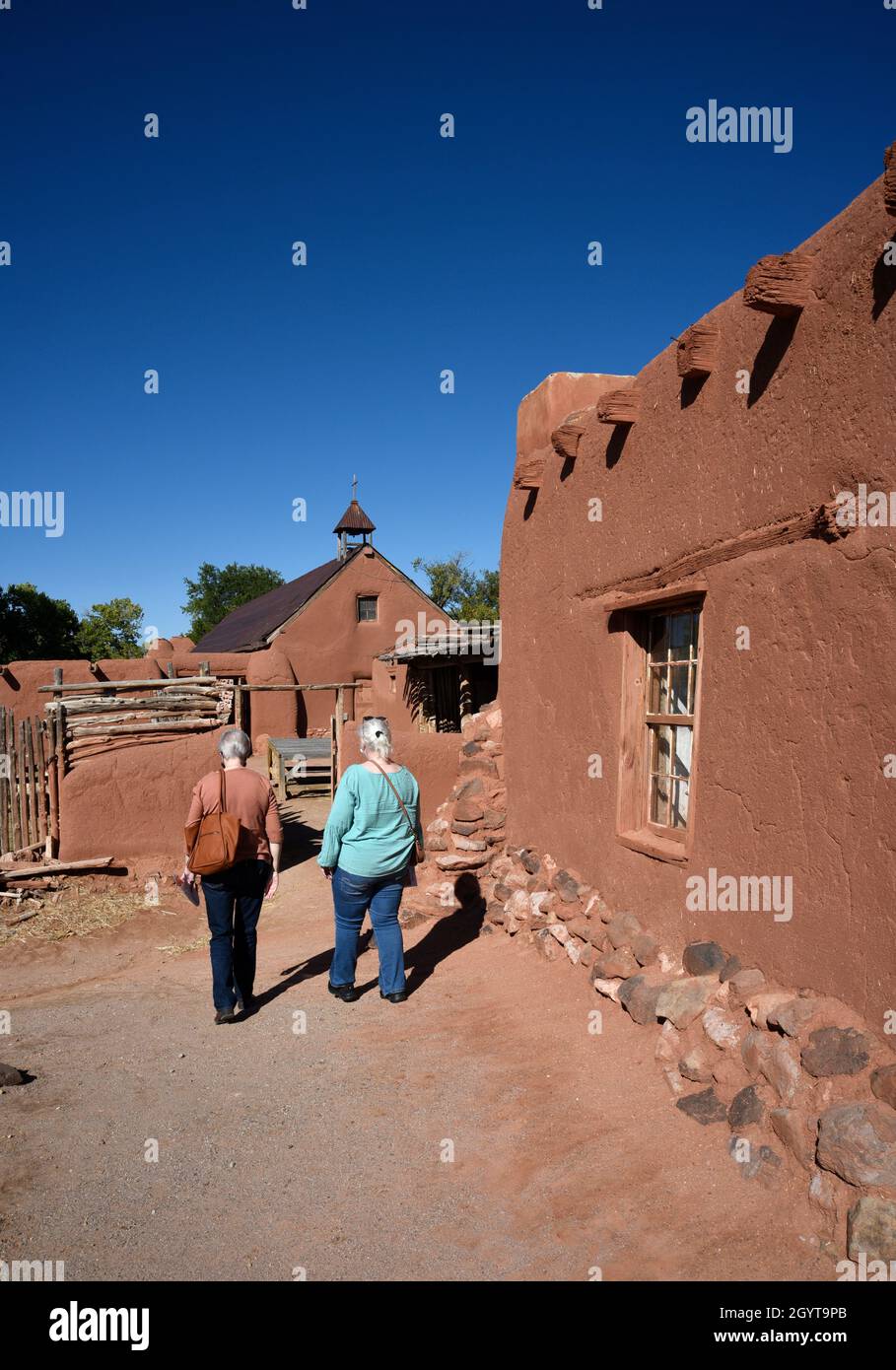 Tourists visit adobe adobe structures El Rancho de las Golondrinas ...
