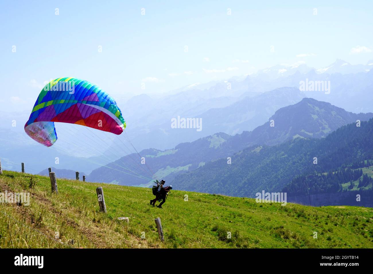 Two persons running to launch a paraglide and catch air current. Tandem ...