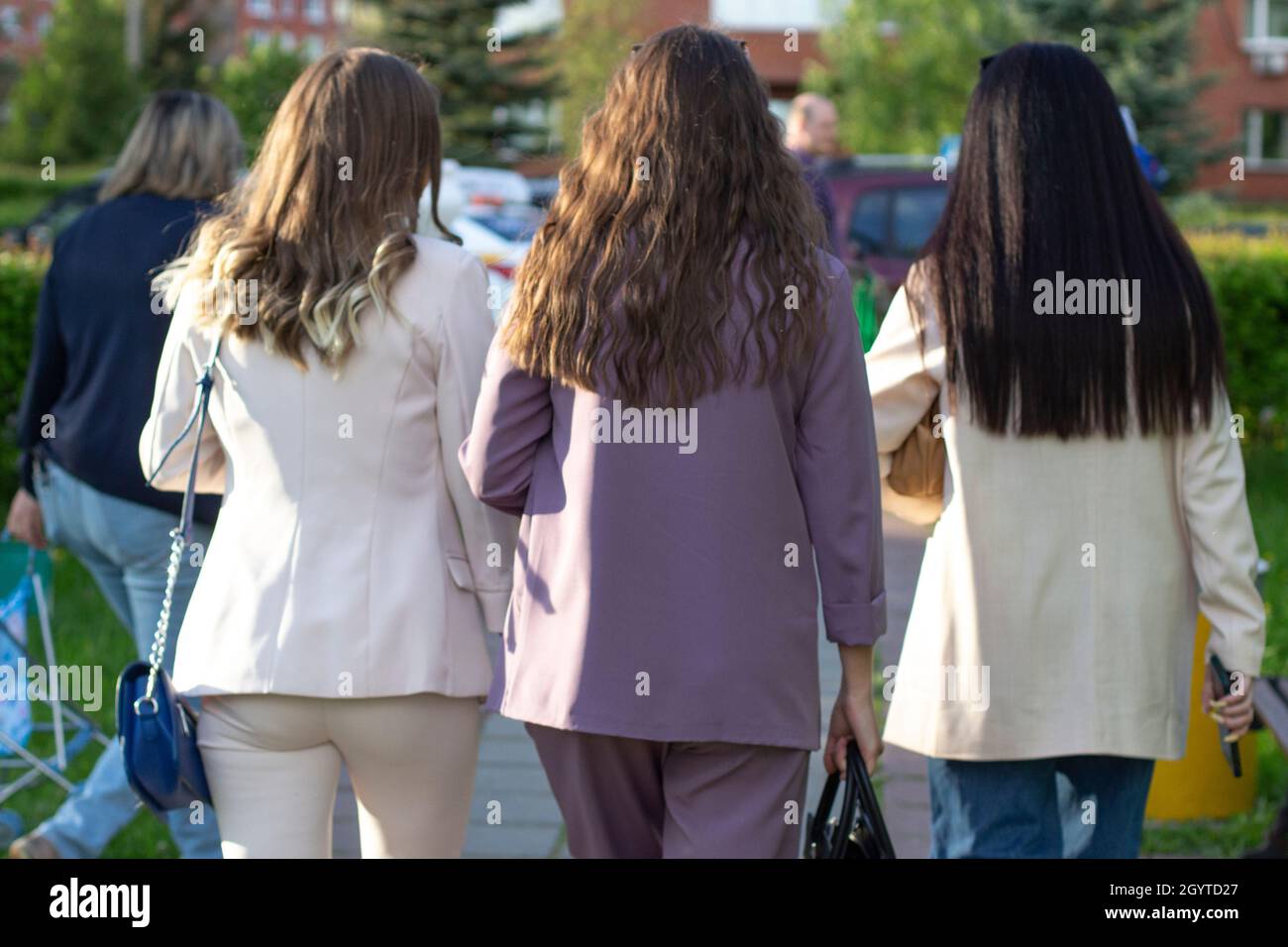 Three girls walking down the street. The girls are walking down the ...