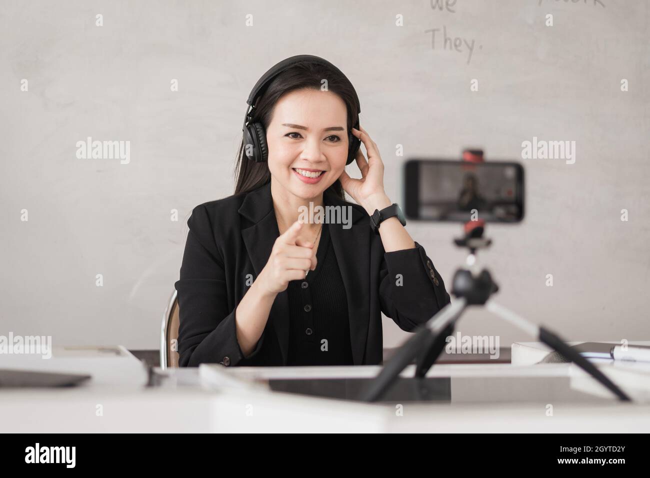 Asian female tutor recording an online lesson Stock Photo - Alamy