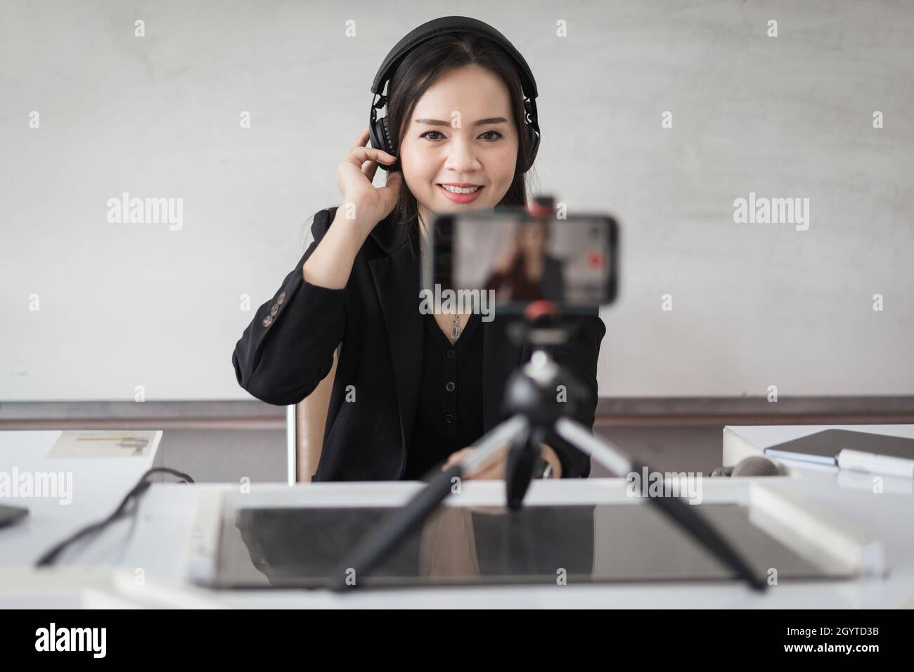 Asian female tutor recording an online lesson Stock Photo - Alamy